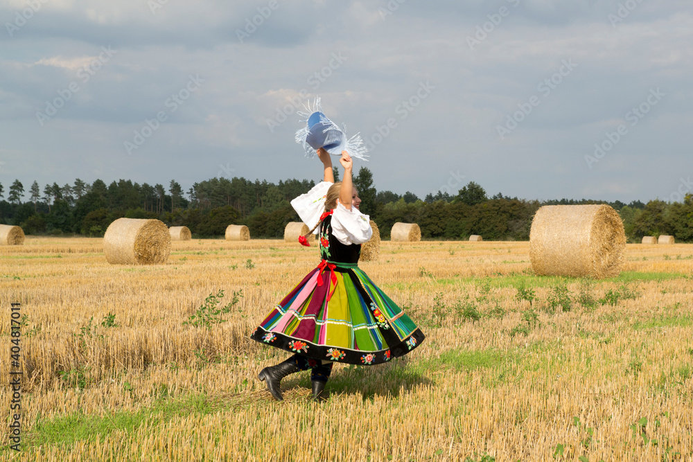 Blonde pretty young smiling girl dressed in Polish national folk dress ...