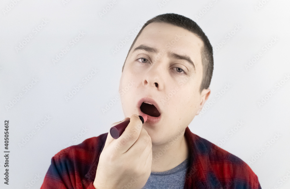 Close-up of a man painting his lips. The concept of protecting the ...