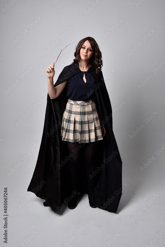 full length portrait of pretty brunette woman wearing tartan skirt and boots with long black ...