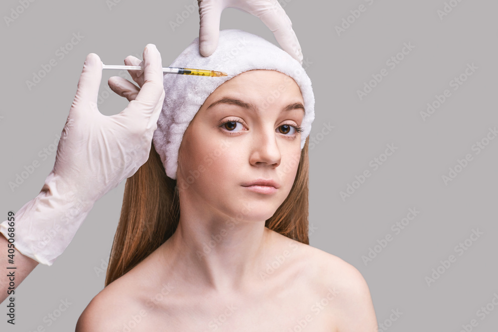 Forehead injection at spa salon. Doctor hands. Pretty female patient ...