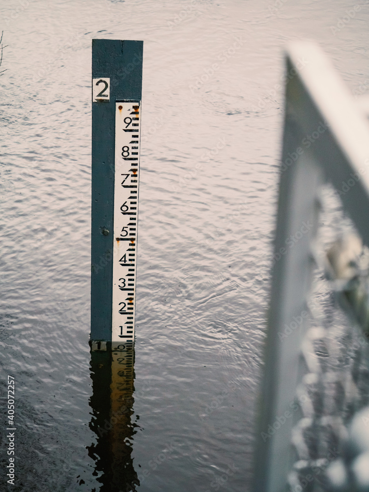 Water depth measuring pole in a river to gauge high or low level of ...