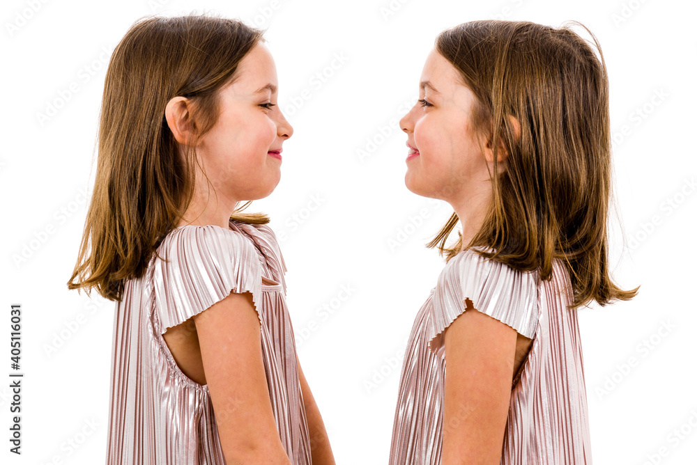 Identical twin girls are looking at each other and smiling. Stock Photo ...