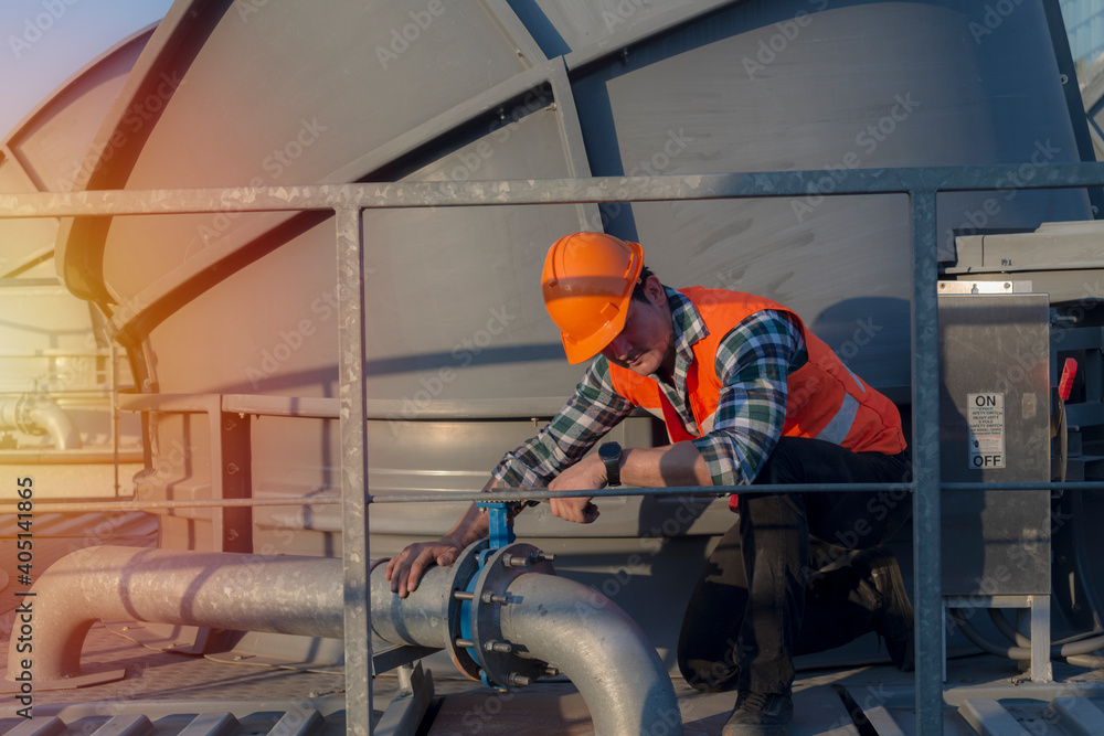 worker open valve of cooling tower on blue sky background.worker ...