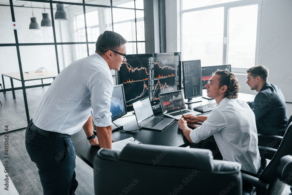 Conception of teamwork. Team of stockbrokers works in modern office ...