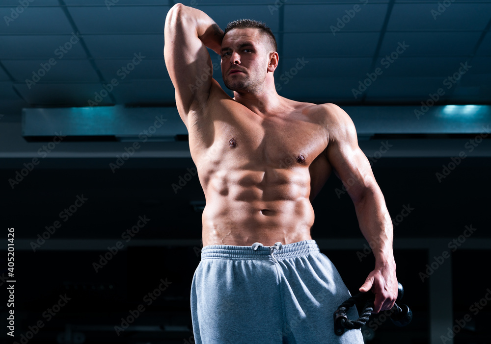 Muscular man working out in the gym. Athlete in the gym training close ...