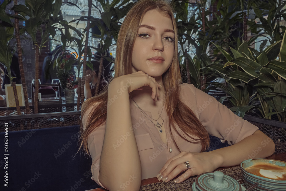 Heartbroken lady sitting in cafeteria. She is looking sad and ...