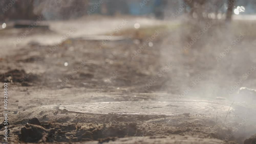 iron hatch smoke heating main in urban infrastructure. smoke steam from ...