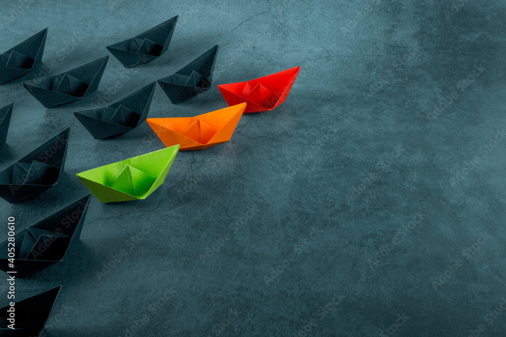 Team work concept using different color origami paper boats. Leadership ...