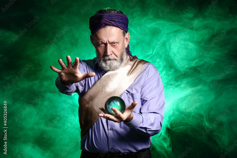 Male fortune teller with crystal ball on dark color background Stock ...