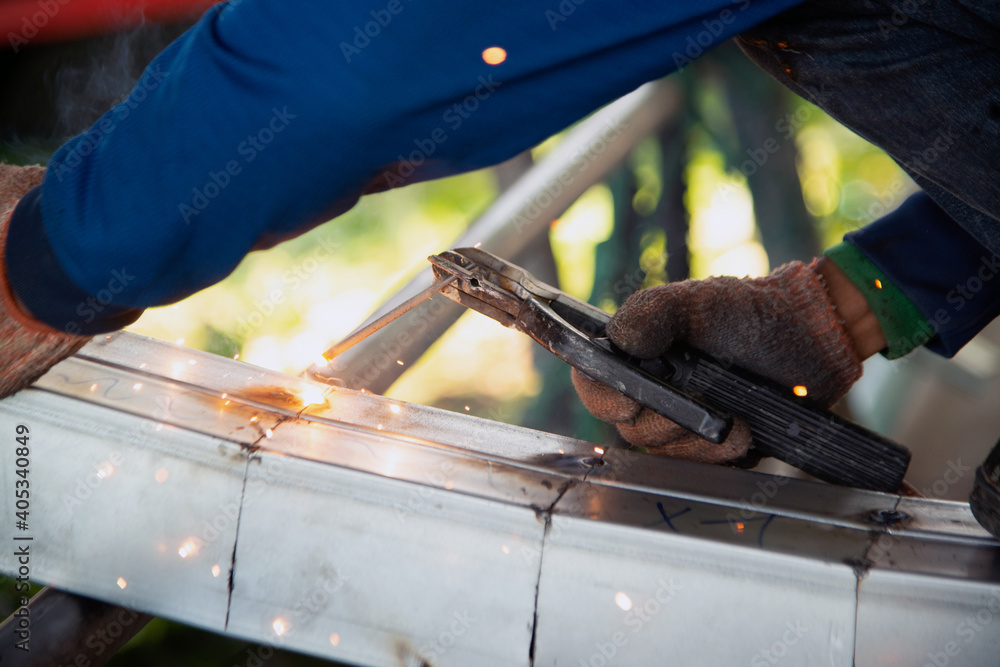 Welders weld metal fences by welding machines. Stock Photo | Adobe Stock