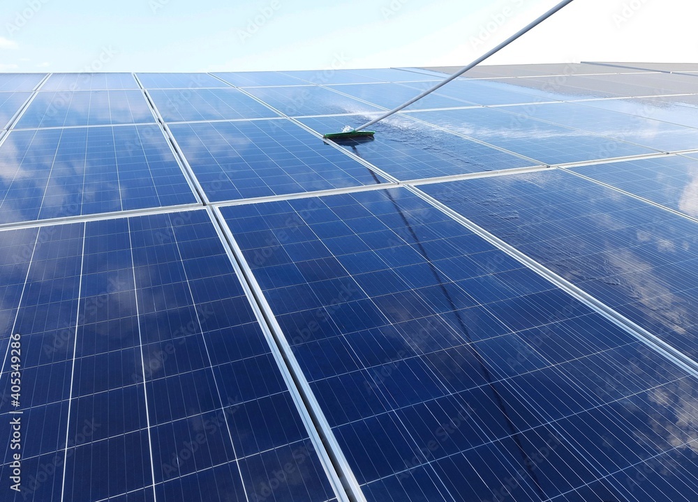Cleaning solar modules with wiper and water, sky reflection on solar ...