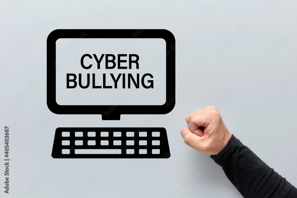 Male fist with a computer icon with cyber bullying written on the ...