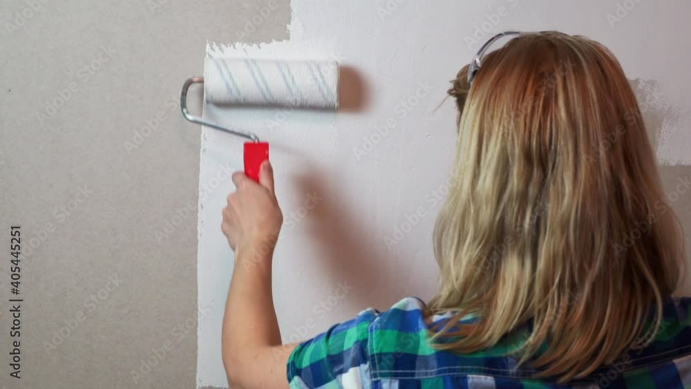 woman with painting roller and white paint coloring drywall Stock Video ...