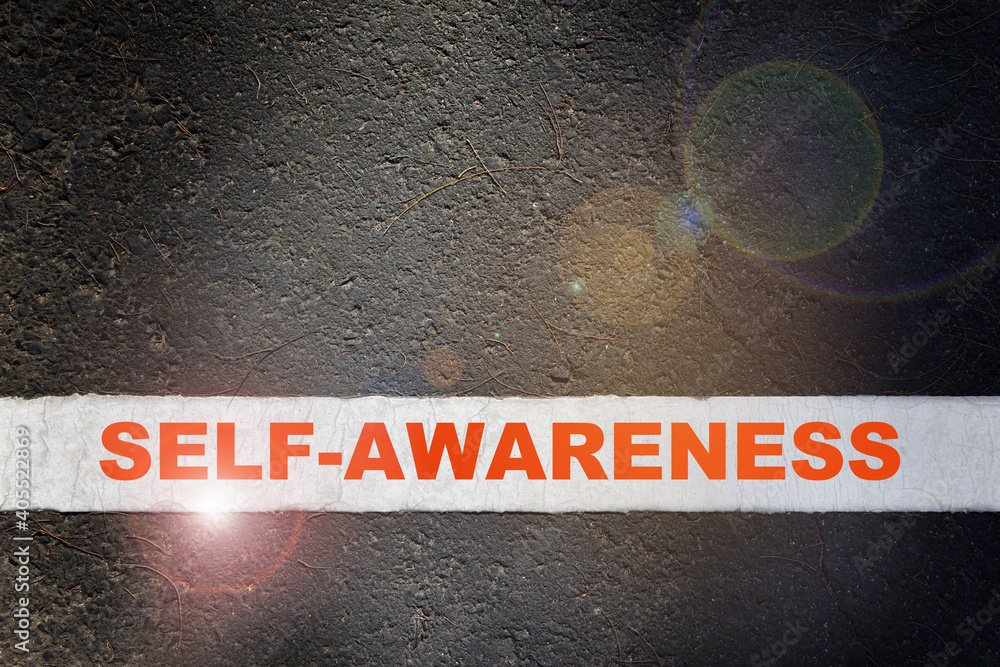 Self awareness written on white starting lines on road surface ...