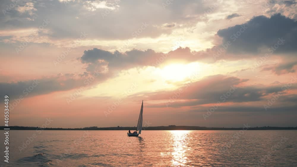 Cinematic scene. A small sailing boat yacht goes on a quiet water ...