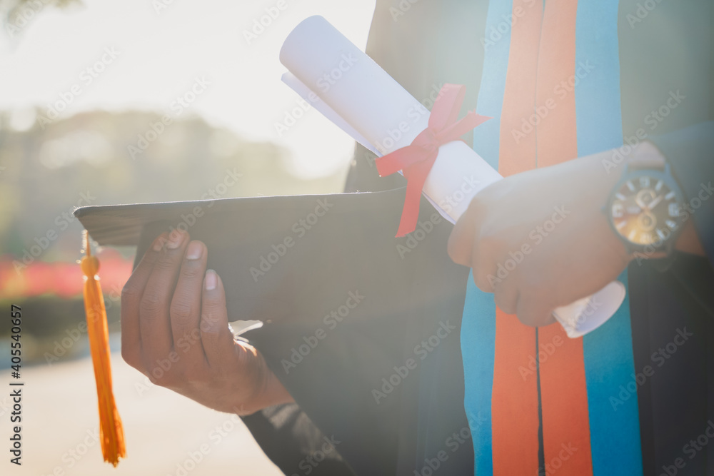 Selective and close-up focus of a university graduate holds a degree ...