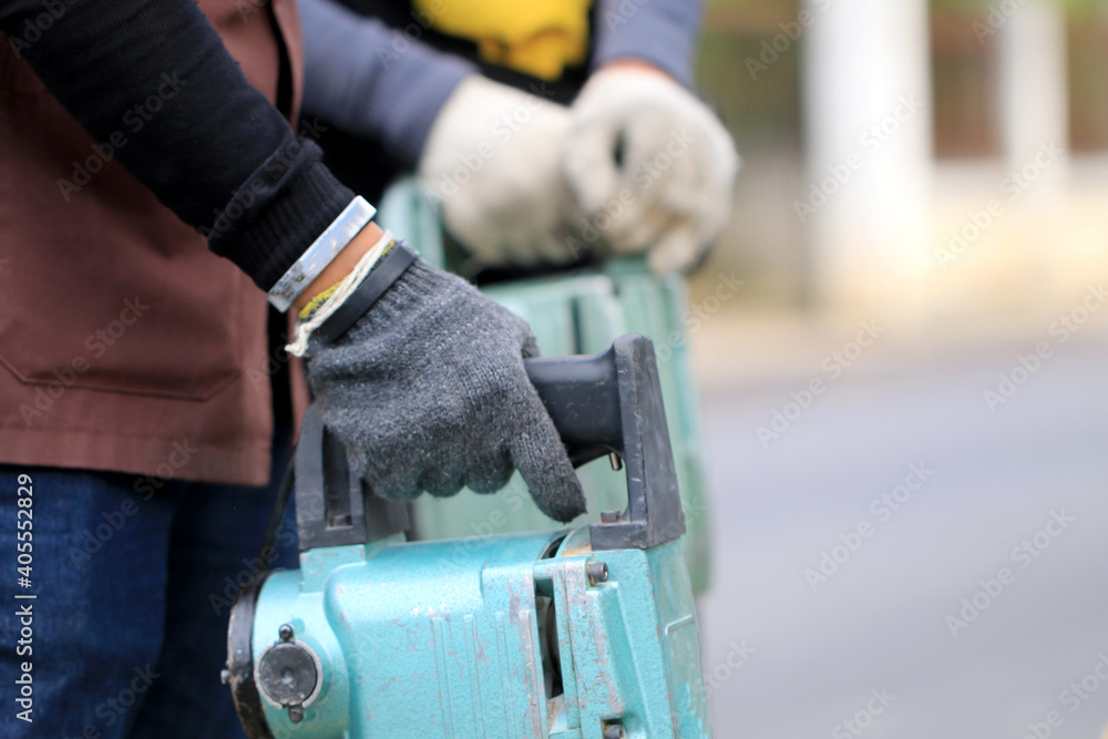 Male workers use electric concrete breaker for digging and drilling ...