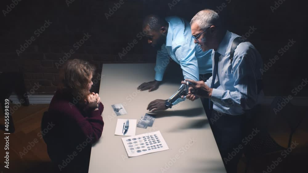 Diverse Detective Interrogating Scared Arrested Woman And Threatening