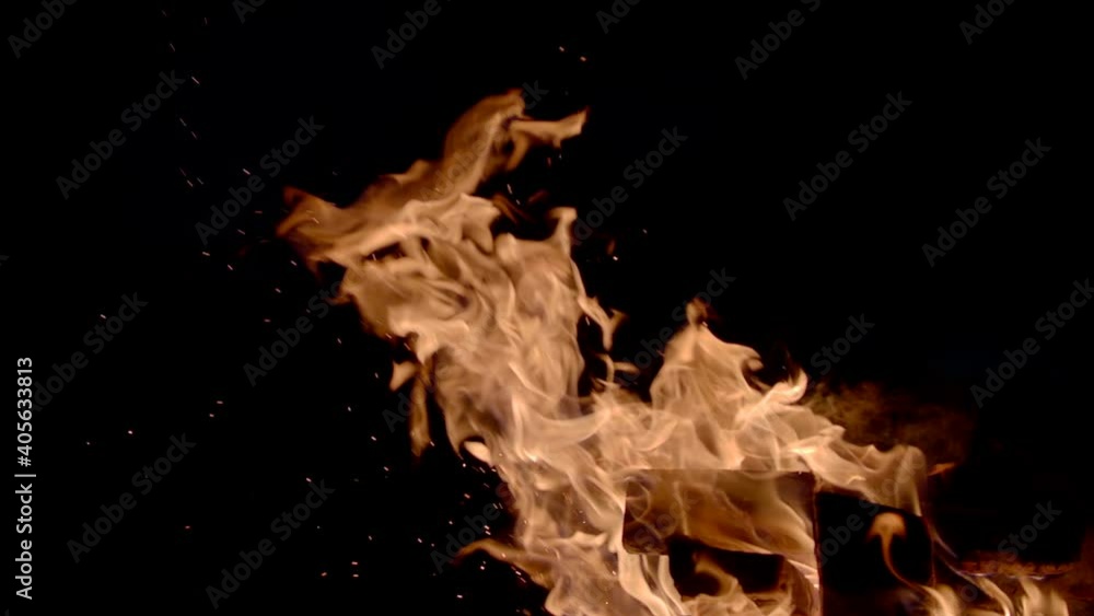 Burning hot firewoods fire sparks on a dark background. Raging Campfire ...