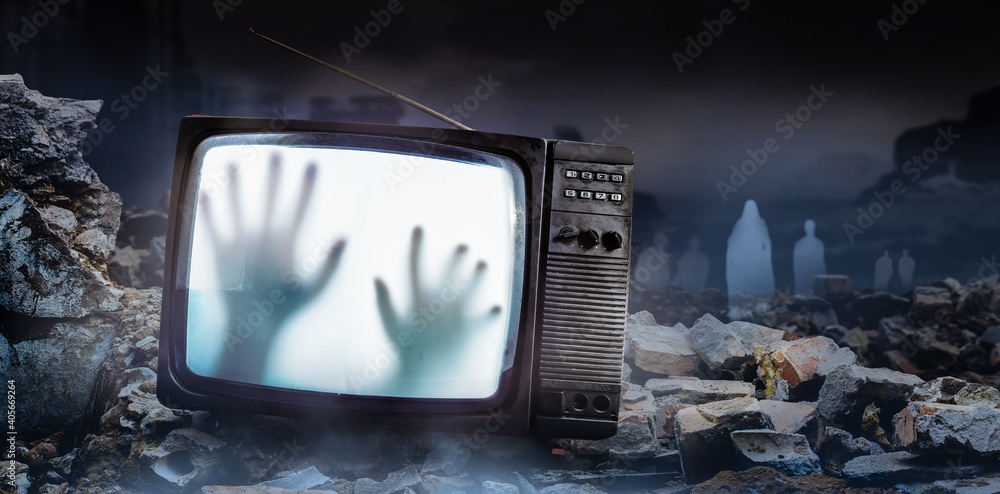 Horror photo of an old black scary haunted tv set with ghost hands on screen, standing on dark ...