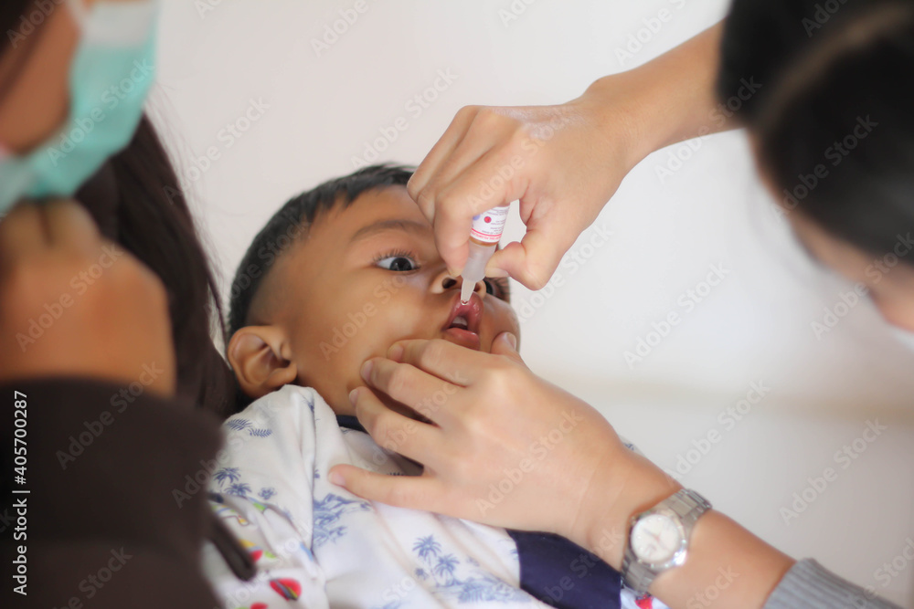 Nurse making infant oral vaccination against rotavirus infection ...