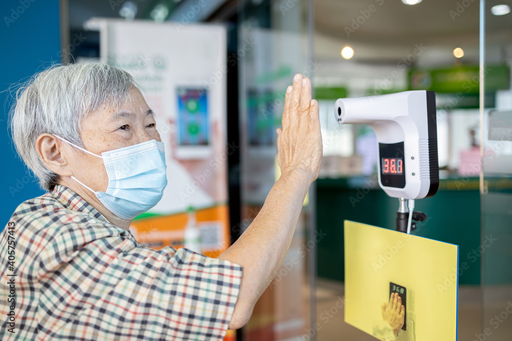 Asian senior woman using infrared digital thermometer measurement,body ...