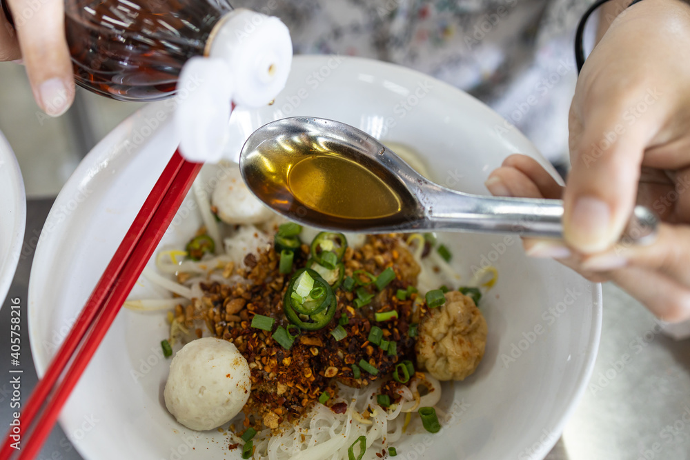 Hand of woman holding Thai sauce used as a condiment,prepared from ...