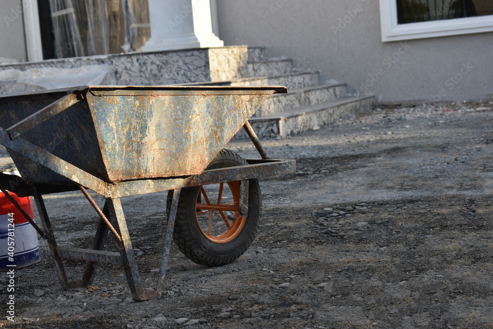 wheelbarrow in an under construction site, villa under construction ...