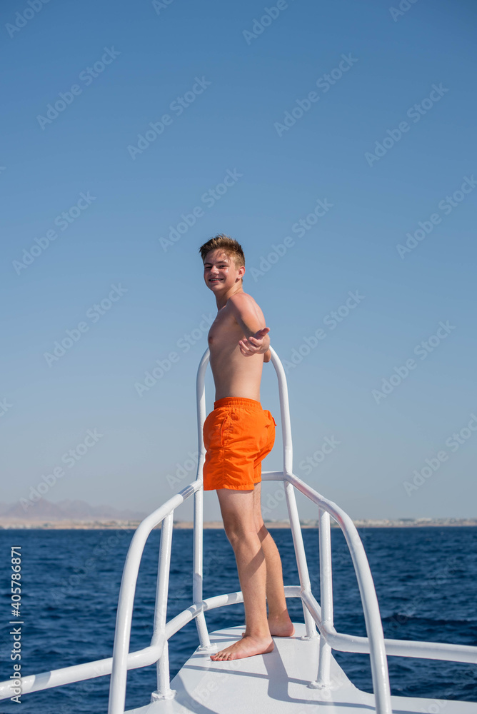 Joyful young cute teenage boy portrait. Happy boy staying on deck of ...