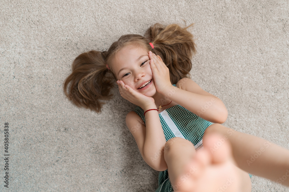 Cute preschool girl making funny faces, playing, having fun while lying ...