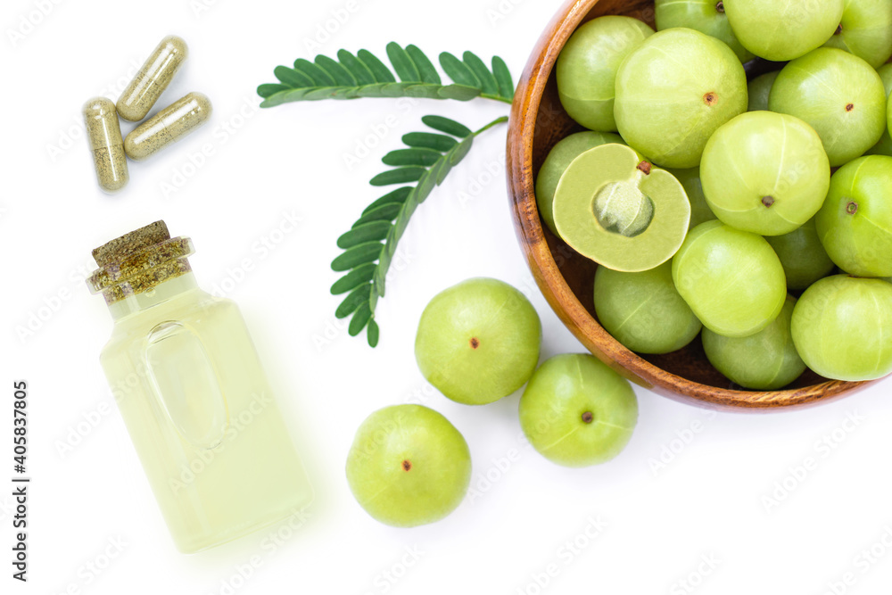 Indian gooseberry or Amla fruit with green leaf, bottle of essential ...