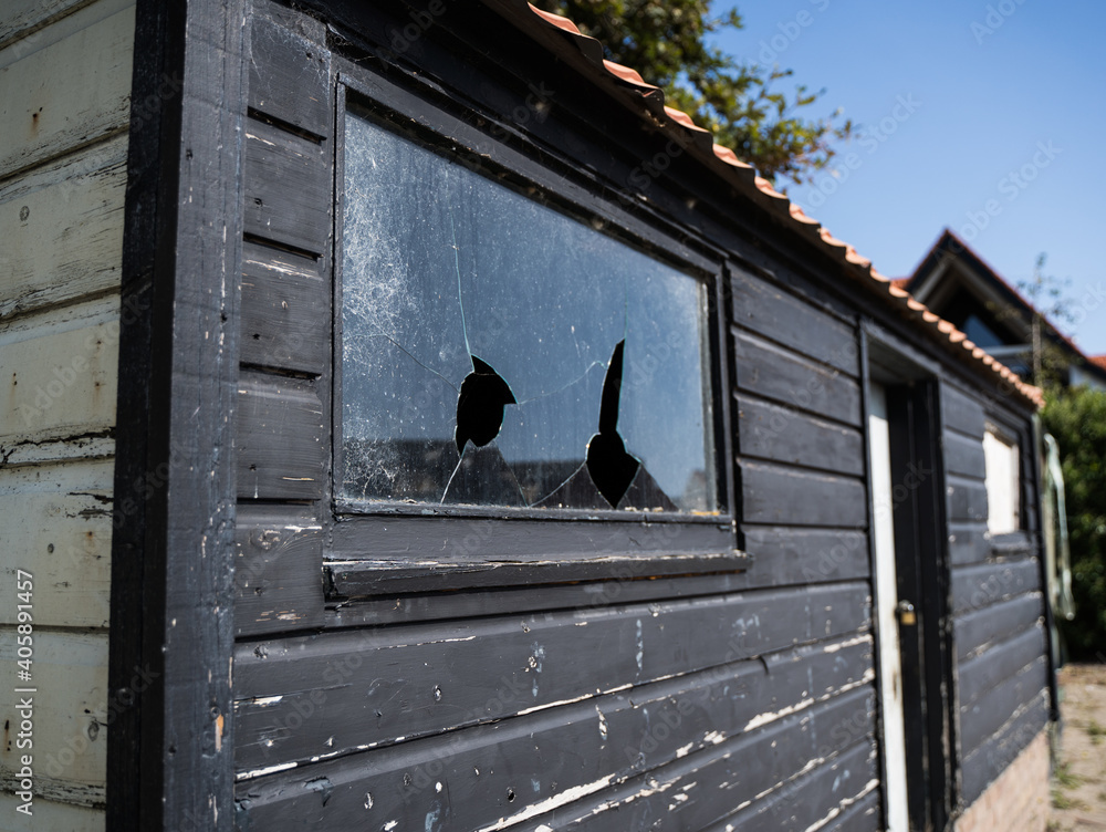 Damaged, old shed with broken glass/window Stock Photo | Adobe Stock