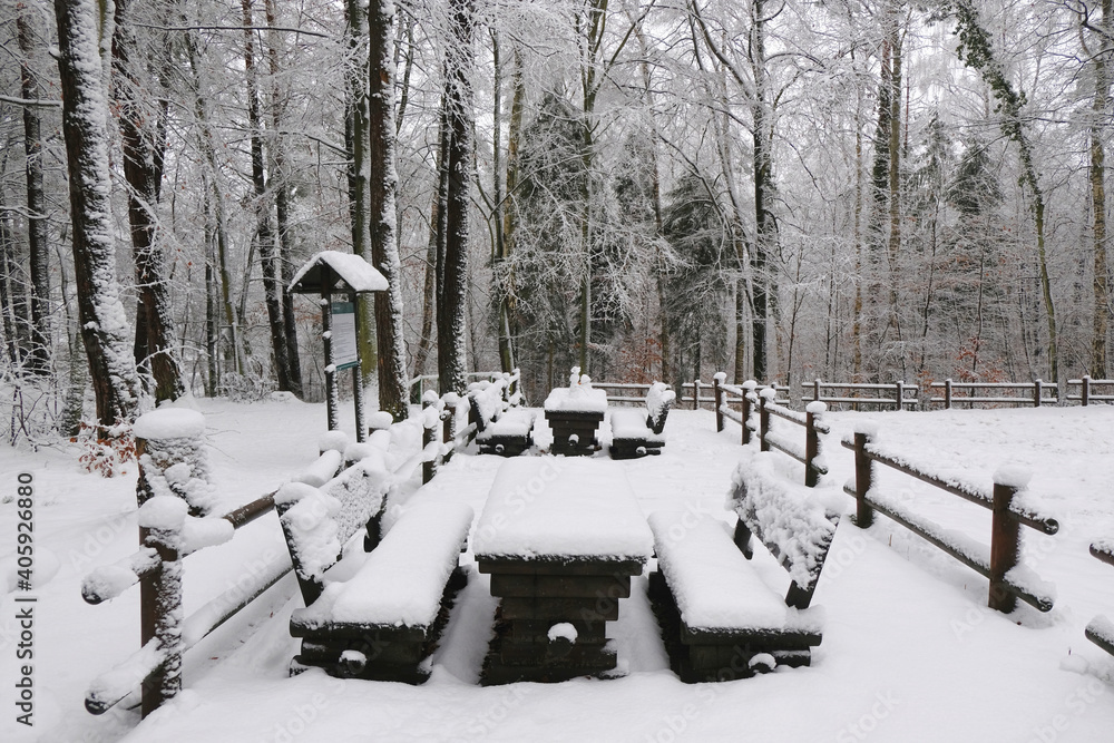 Forest parking lot with rest area with wooden benches covered with snow ...