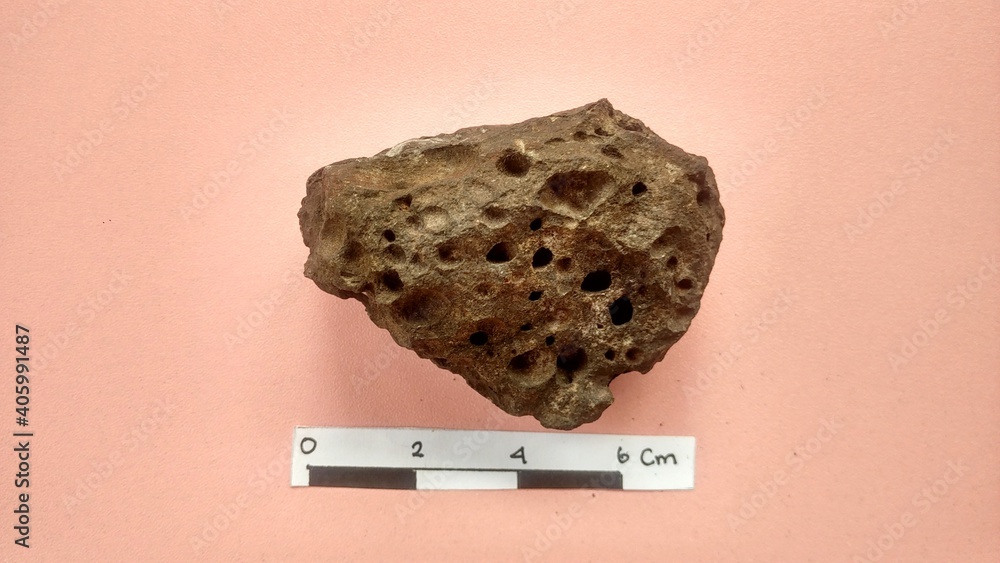 Extrusive volcanic igneous rock, vesicular basalt. Dark brown and ...