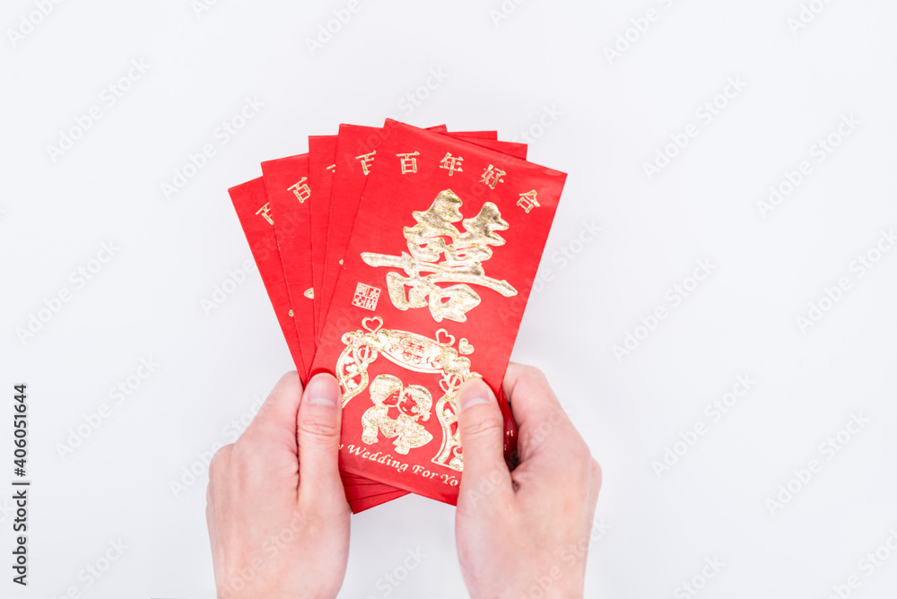 Hand over a stack of Chinese wedding red envelopes on white background ...