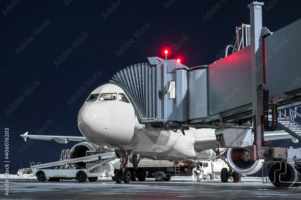 Ground handling of a white passenger aircraft at the boarding bridge on ...