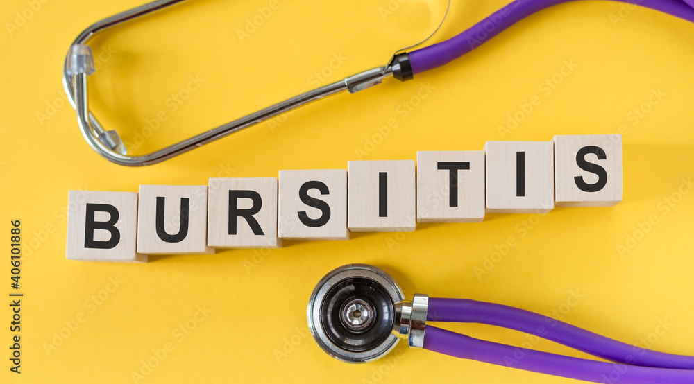 Word BURSITIS building from wooden cubes on yellow desk with ...