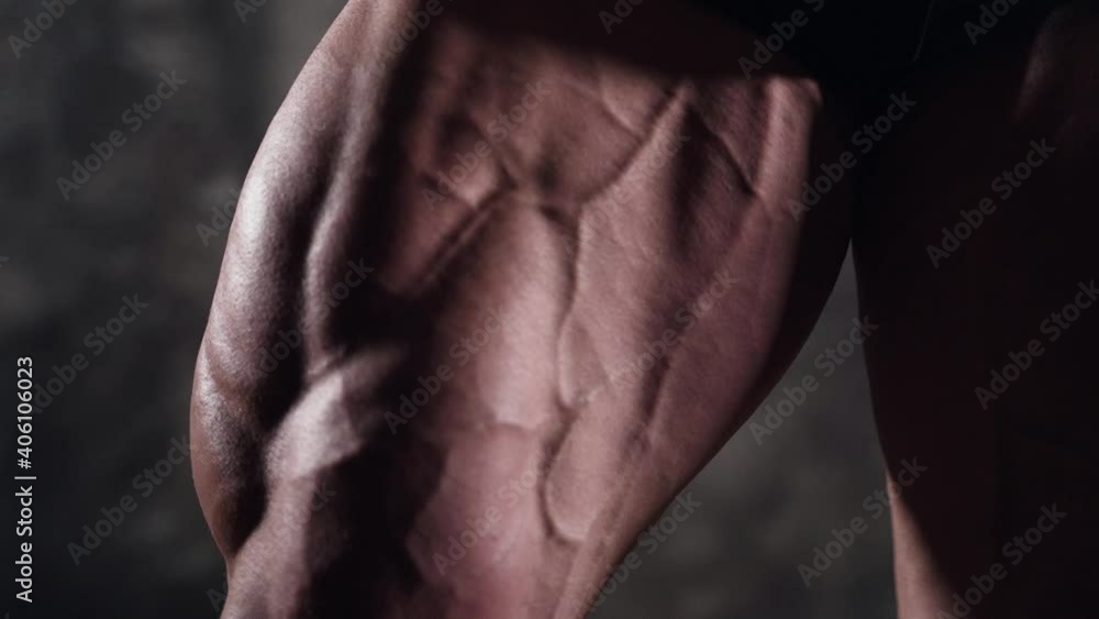 Tense muscles in man's legs. Veins and muscular legs of bodybuilder ...