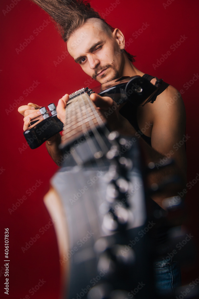 A Punk man with a black electric guitar with a mustache and a large ...