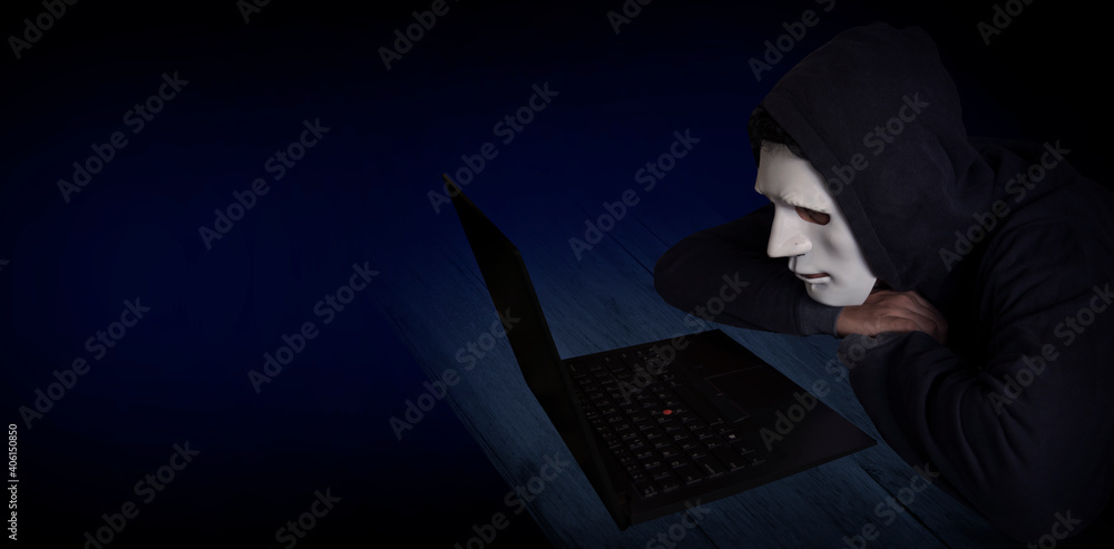 Hacker with white mask in front of laptop. Concept of cyber security ...