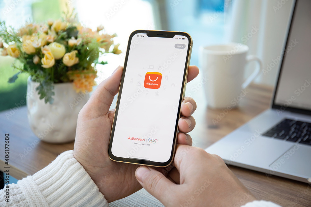 Man hands holding iPhone 12 Pro Max Gold with Aliexpress Stock Photo ...
