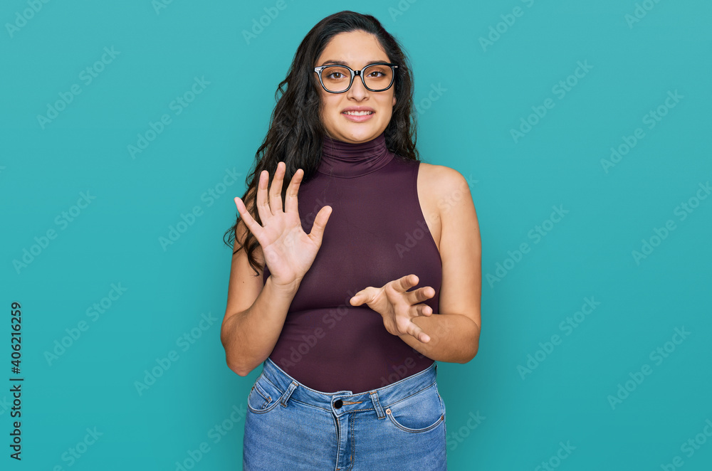 Brunette young woman wearing casual clothes and glasses disgusted ...