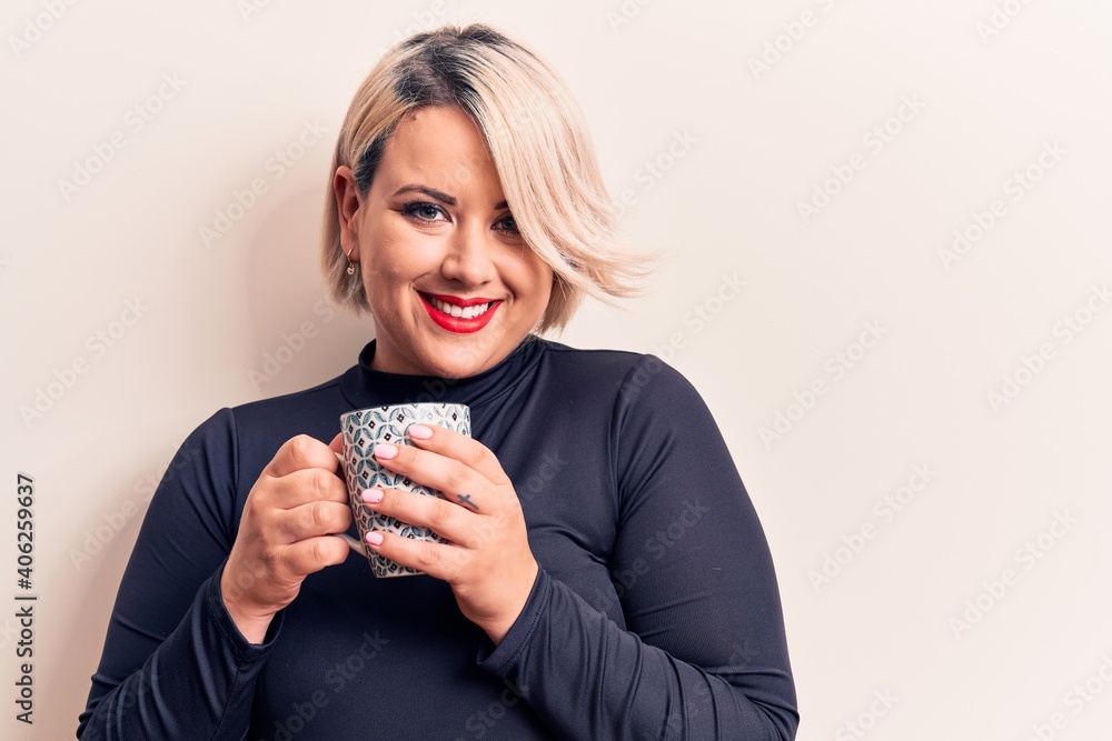 Young beautiful blonde plus size woman drinking mug of coffee over ... Young beautiful blonde plus size woman drinking mug of coffee over ...