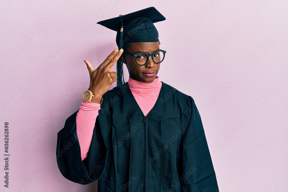 Young african american girl wearing graduation cap and ceremony robe ...