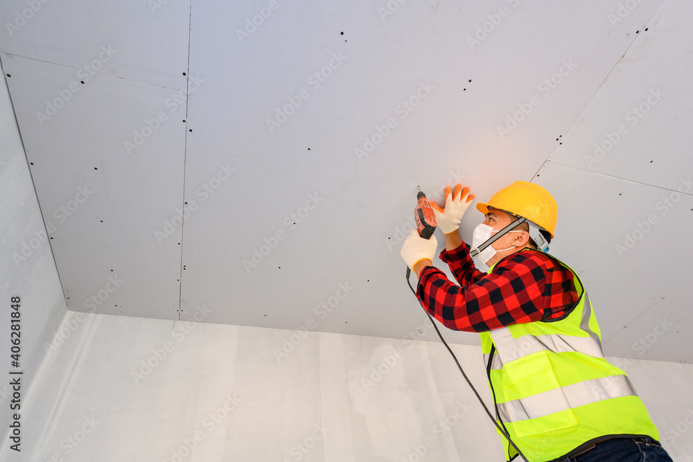 Drill home ceiling Construction workers assemble the ceiling with ...