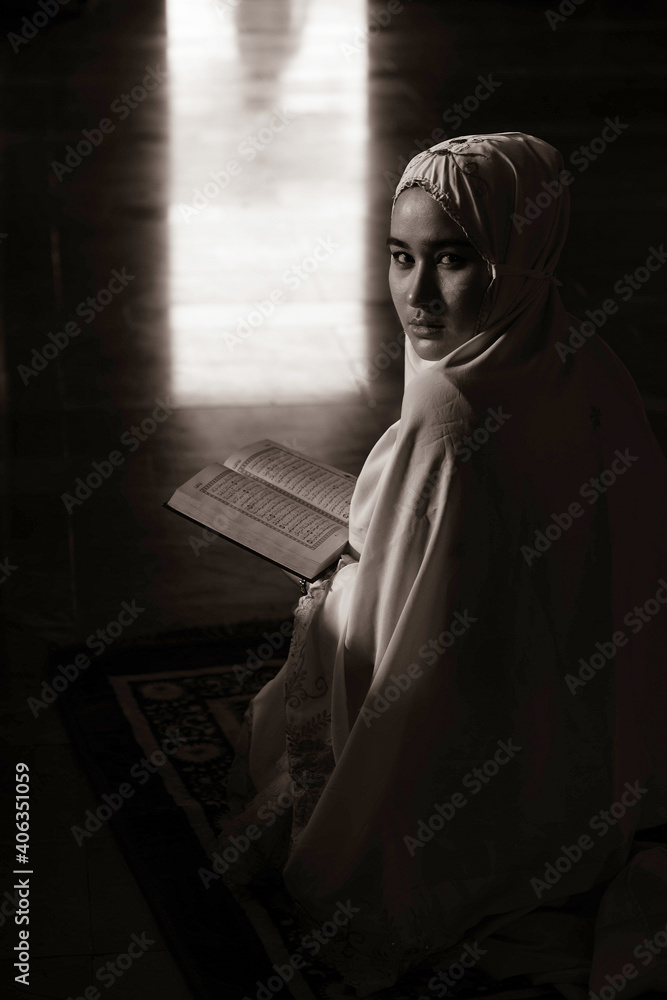 Muslim woman in prayer cap and arabic clothes reading holy quran book ...