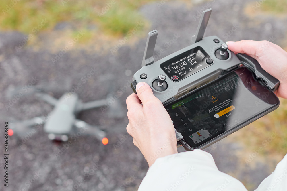 Drone is taking off by remote controller in womans hands. Concept of ...