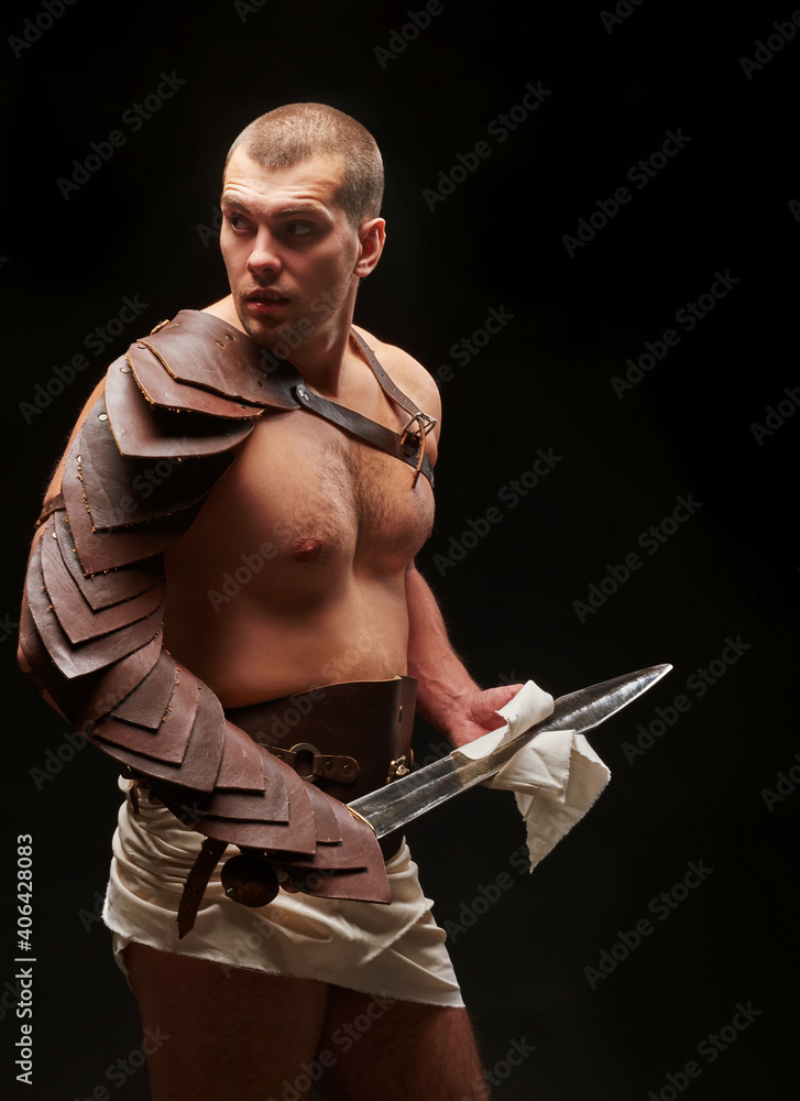 Gladiator with sword and armor on a black background. A warrior in ...
