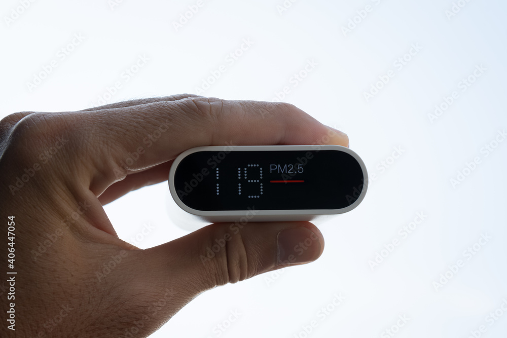 Close Up hand holding air quality monitor to detect level of pollution ...
