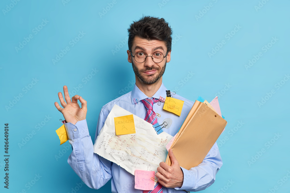 Serious handsome man writes information data shows okay gesture says ...